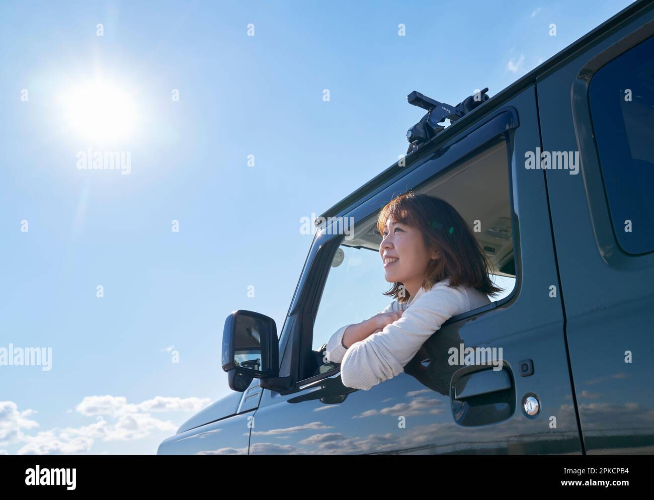 Woman laughing as she looks out the window in the passenger seat of a ...
