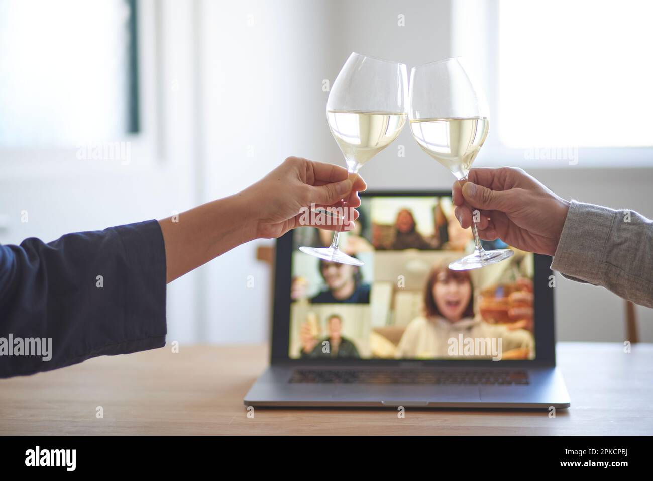 Man and woman toasting hands and computer screen with remote drinking ...