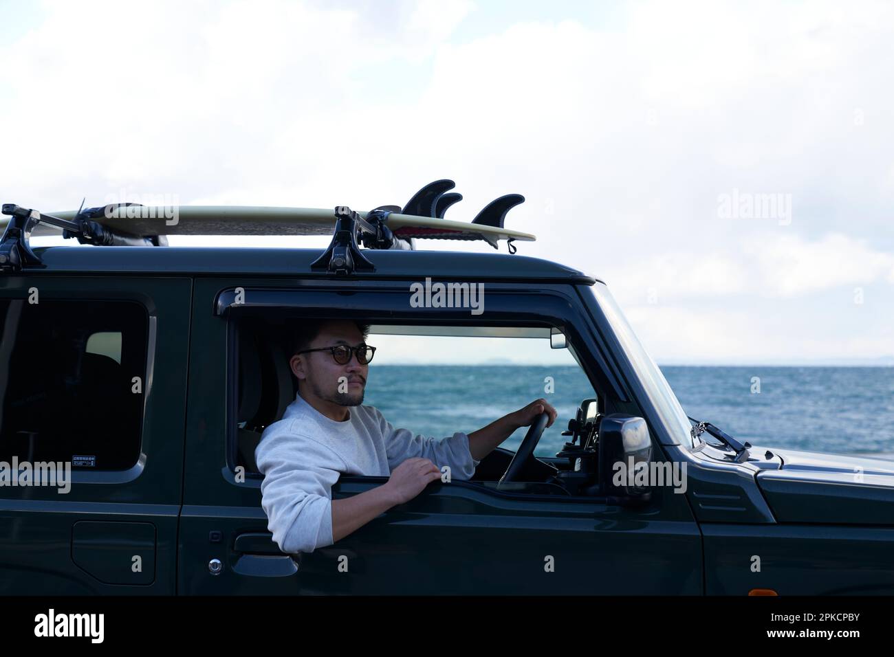 Man placing elbow on car window and looking out Stock Photo - Alamy