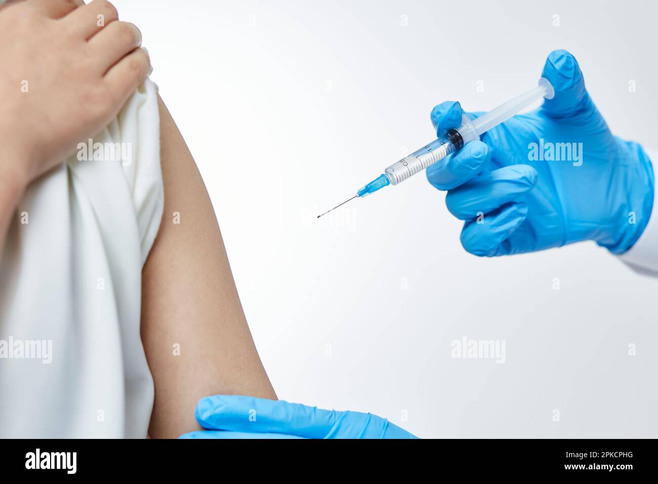 Doctor giving injection into woman's arm Stock Photo - Alamy