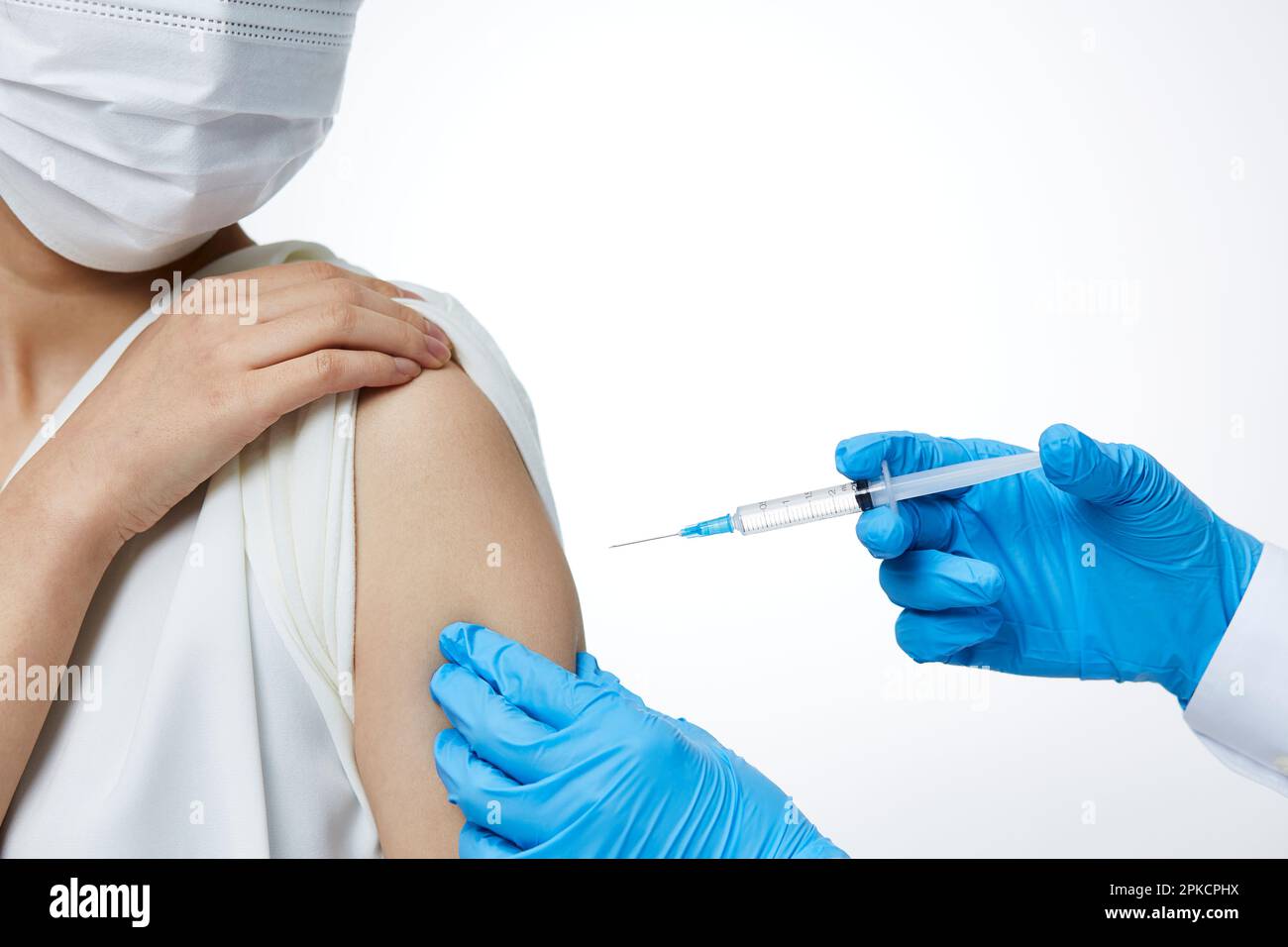 Doctor giving injection into woman's arm Stock Photo - Alamy