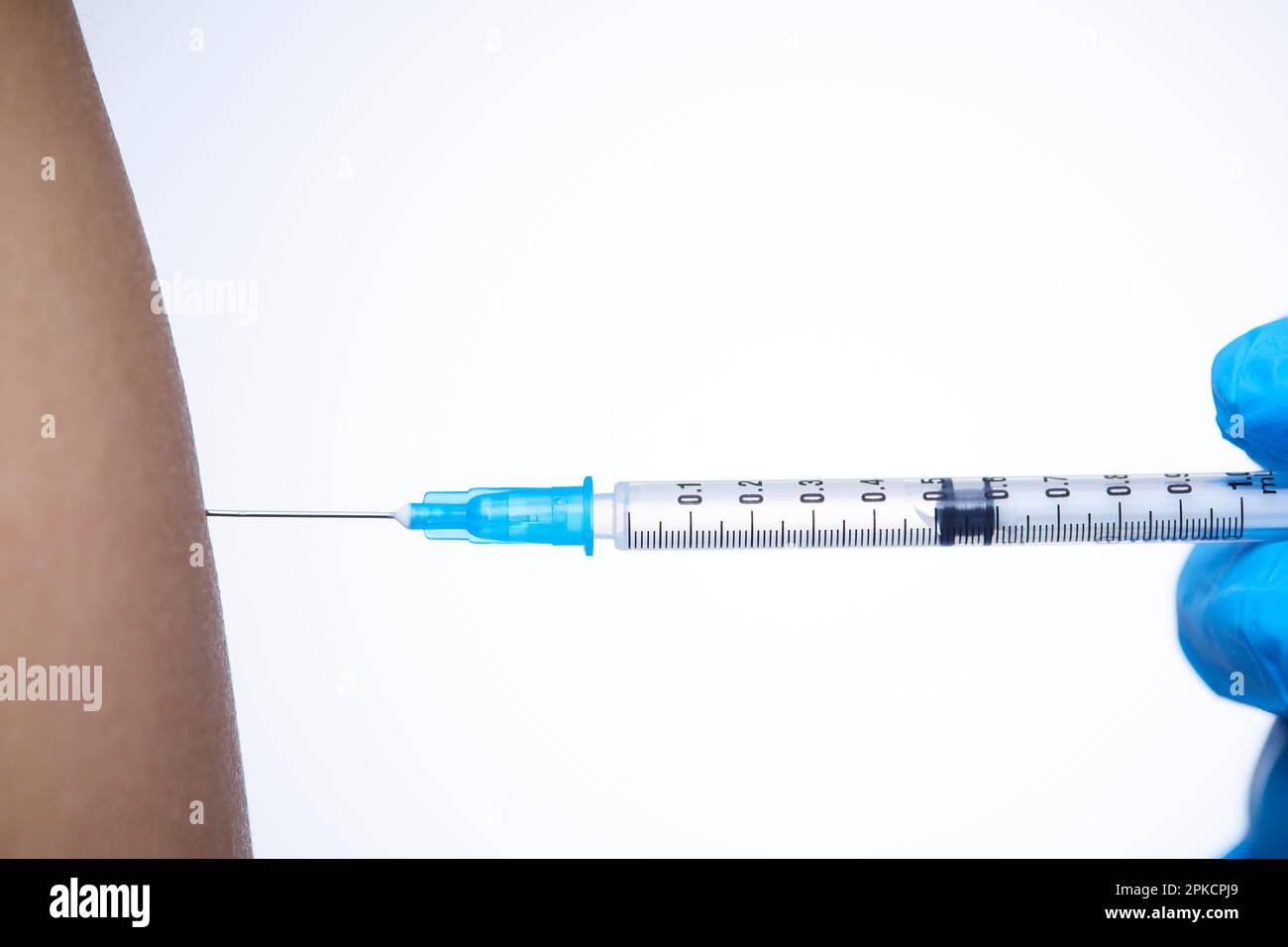 Doctor's hand giving an injection into an arm Stock Photo - Alamy