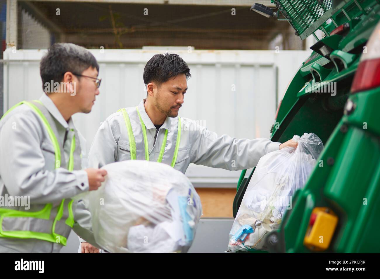 Male worker with a packer truck and garbage collection Stock Photo - Alamy