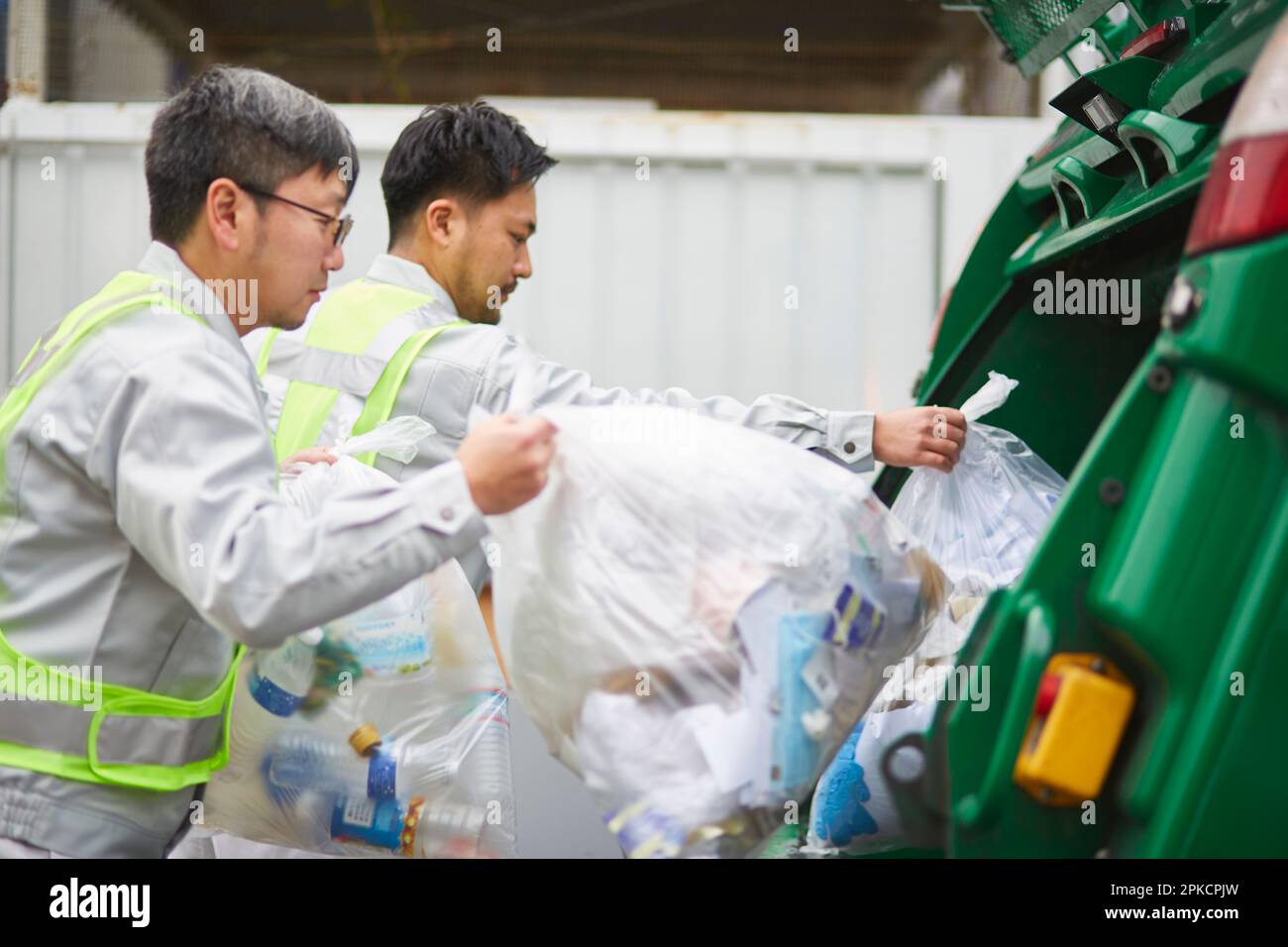 Male worker with a packer truck and garbage collection Stock Photo - Alamy