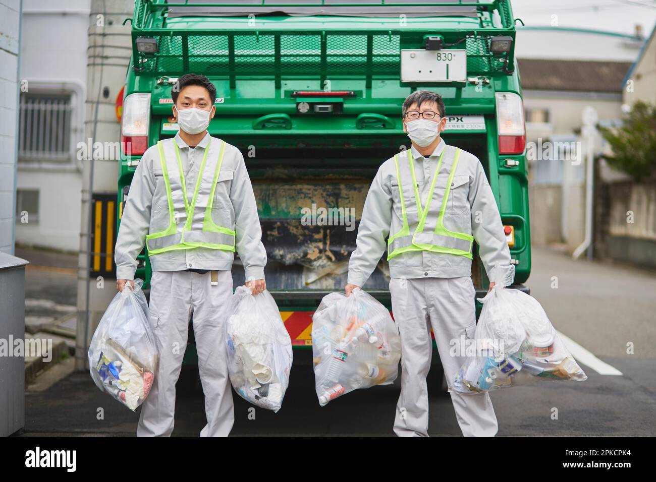 A male worker with a packer truck and garbage collection Stock Photo ...