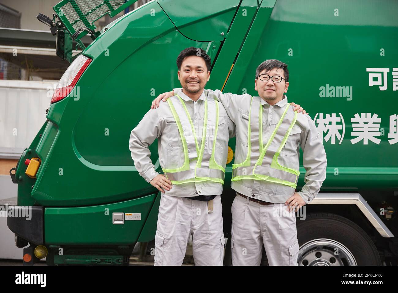 Male worker with packer truck and shoulder Stock Photo - Alamy