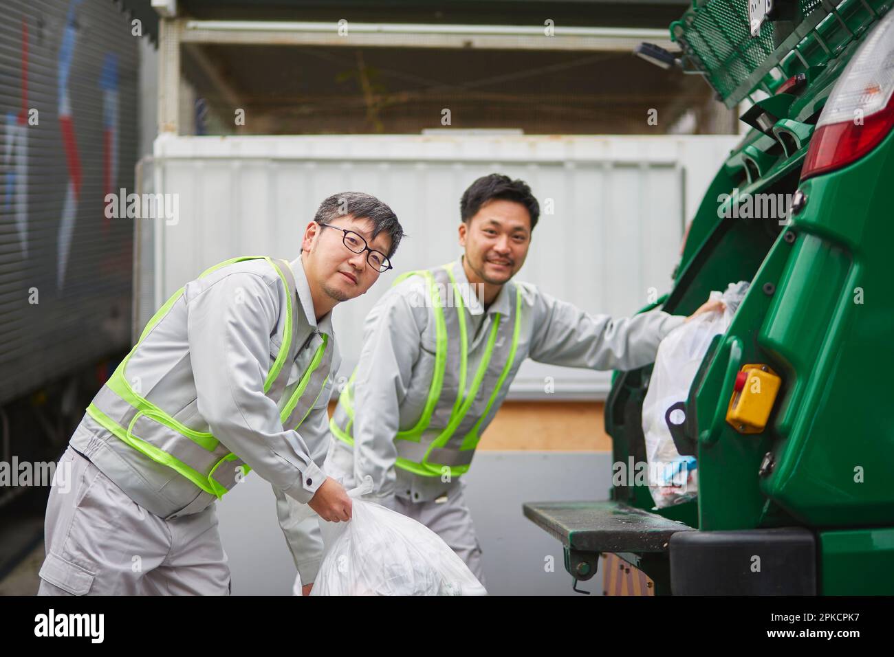 A male worker collects garbage with a packer truck Stock Photo - Alamy