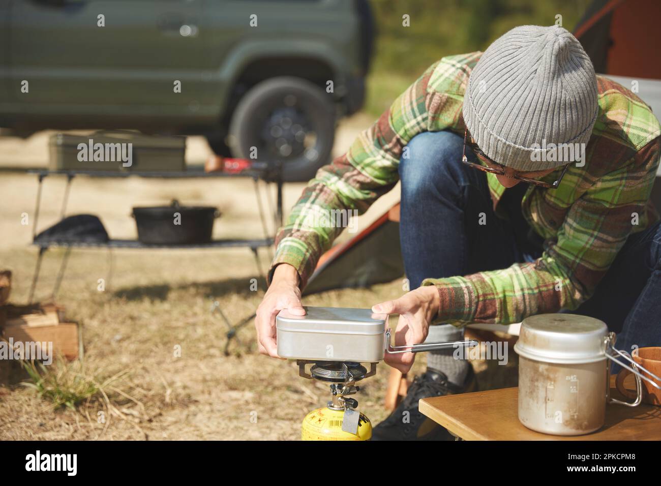 Man cooking rice with gas burner while camping Stock Photo - Alamy