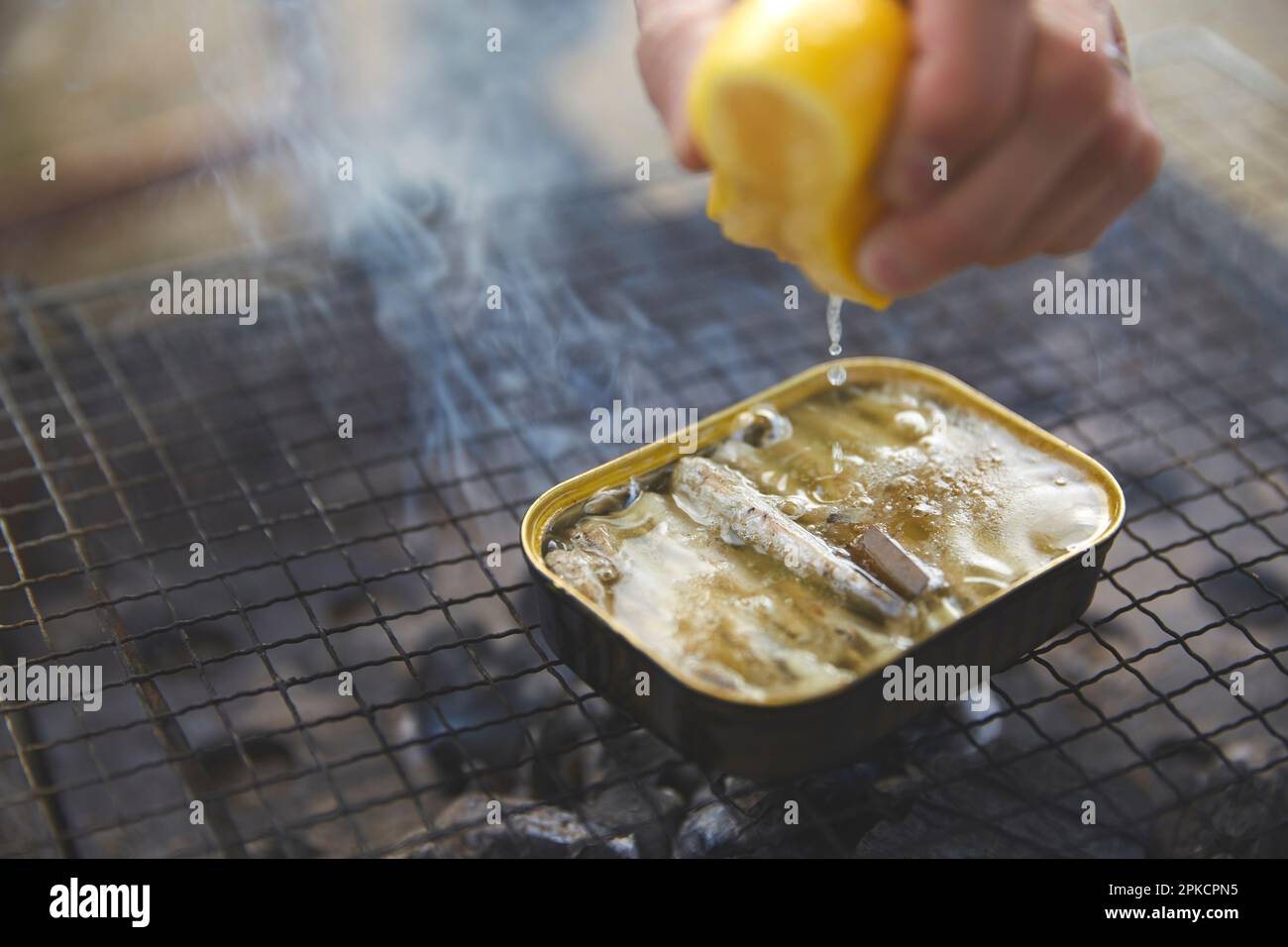 Squeezing lemon over canned food Stock Photo - Alamy