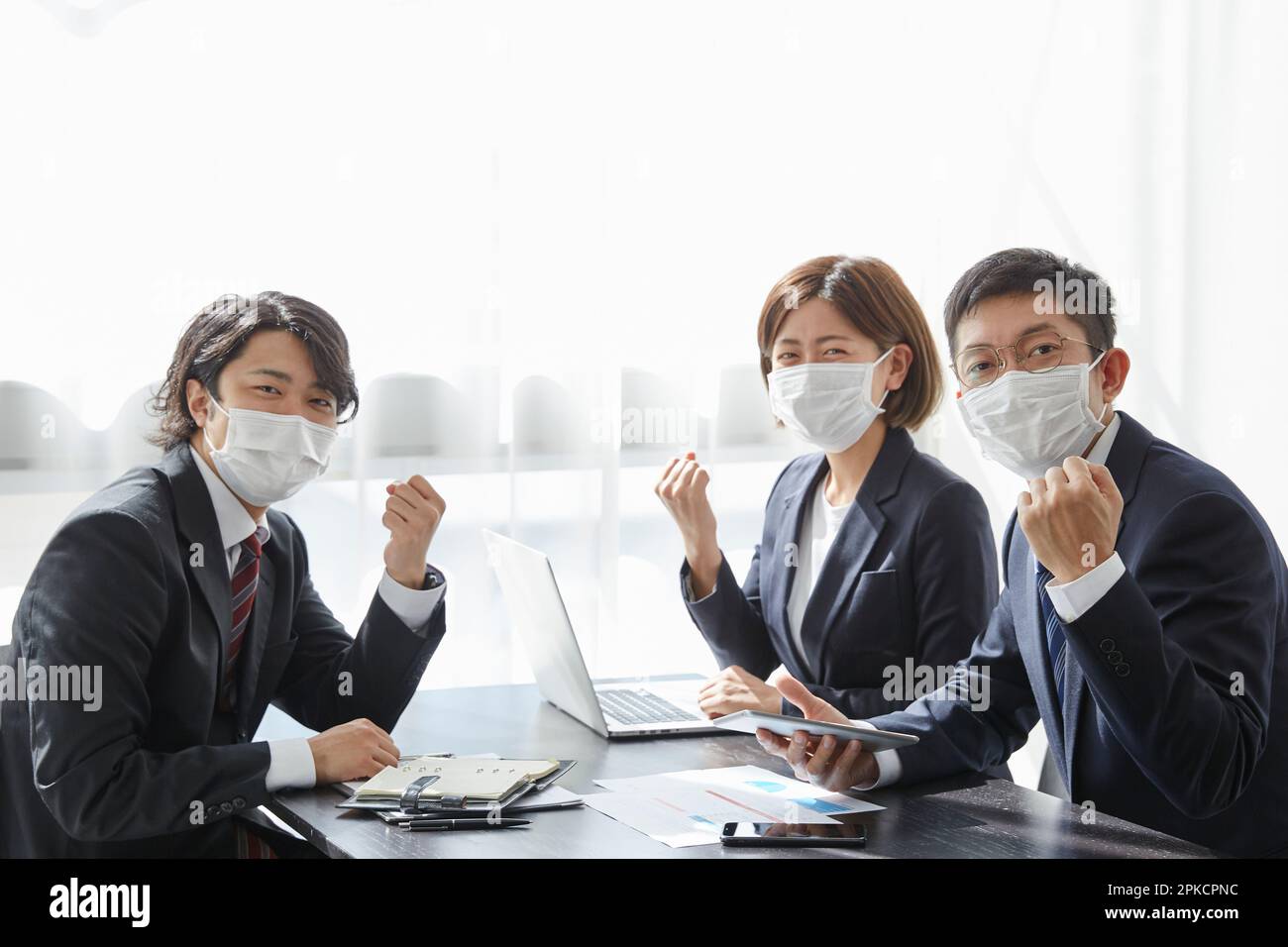 Three office workers wearing masks in an office Stock Photo - Alamy
