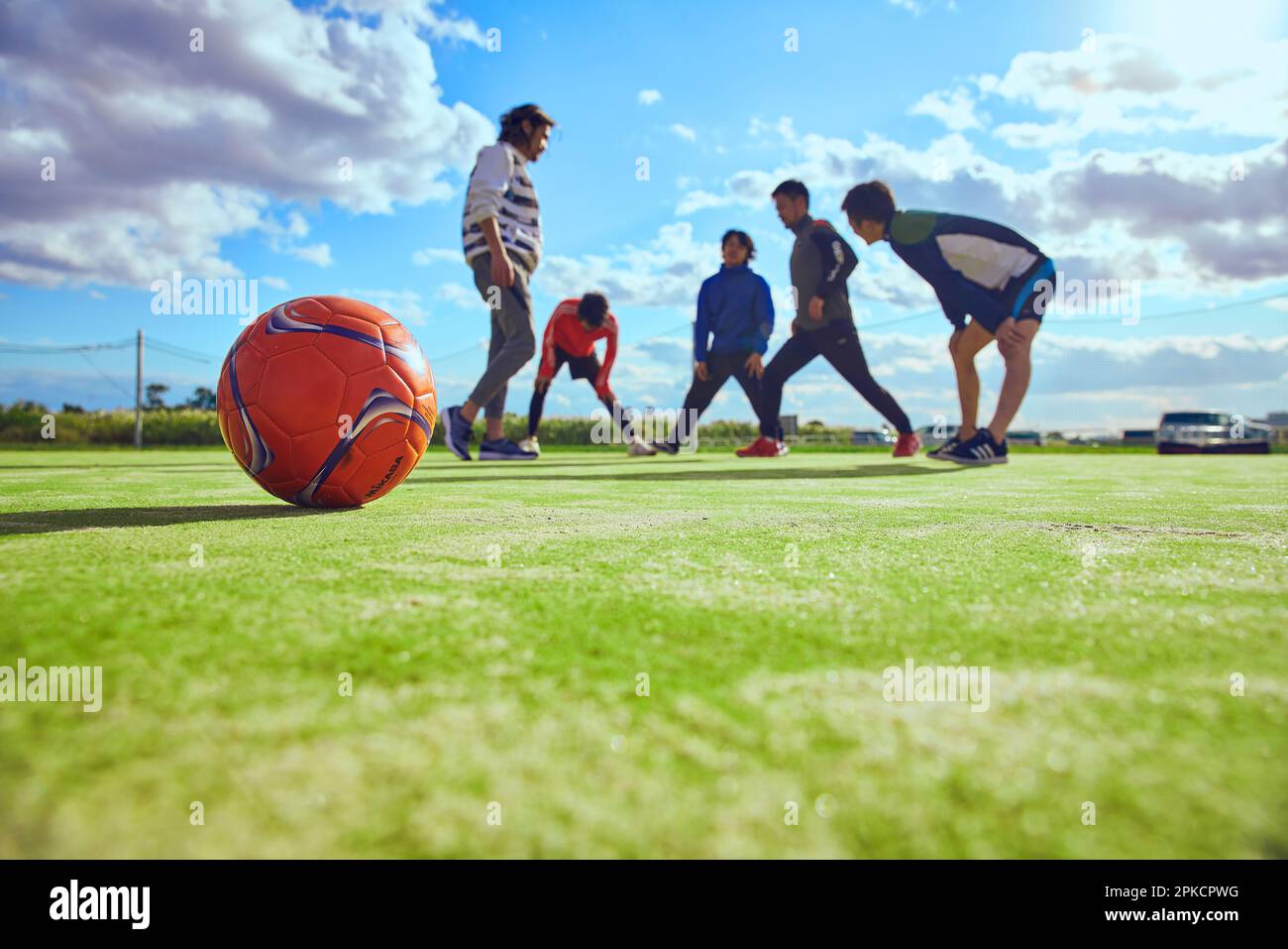 Five sportsmen stretching over a ball Stock Photo - Alamy
