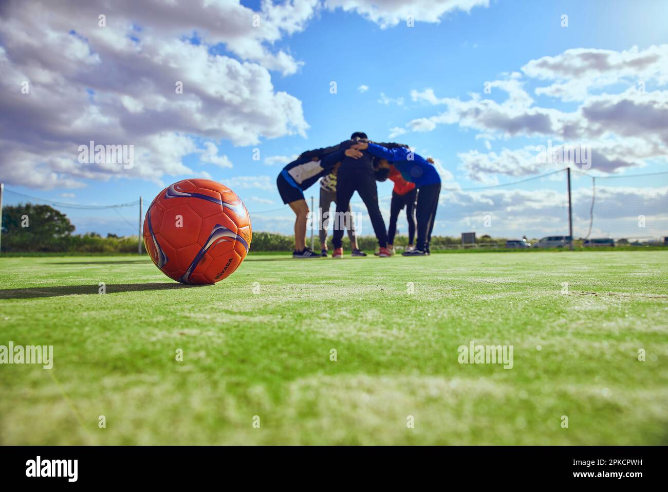 Five sportsmen forming a circle over a ball Stock Photo - Alamy