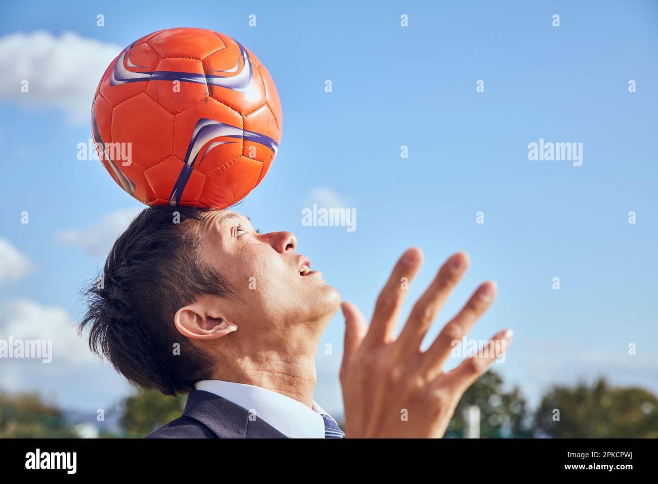 Office worker balancing a ball on his forehead Stock Photo - Alamy