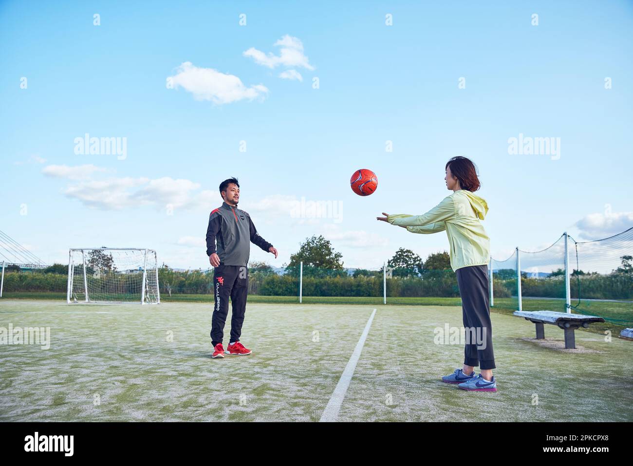 A manager throwing a ball to a player Stock Photo - Alamy