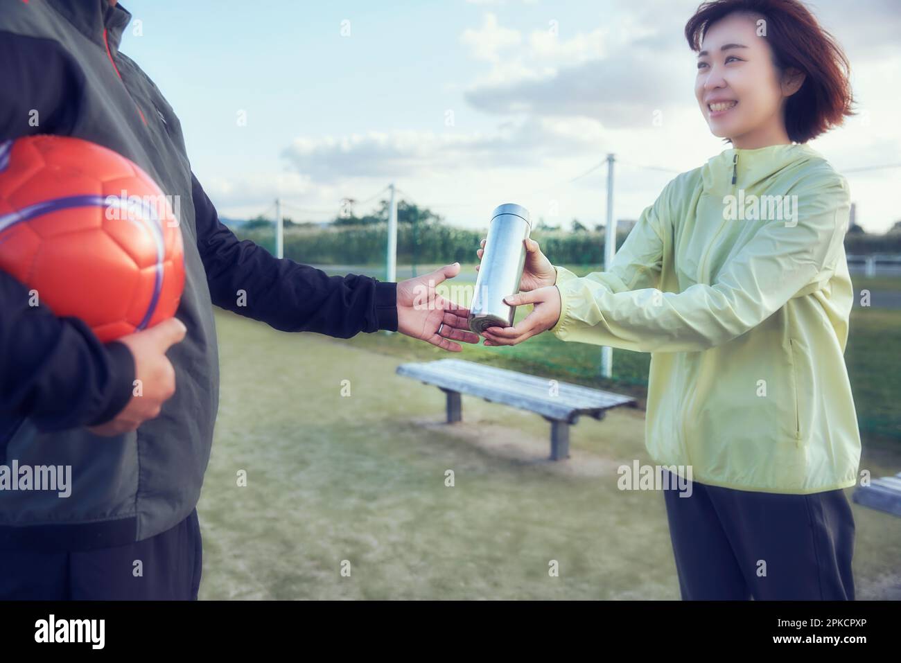 A manager handing a water bottle to a player Stock Photo - Alamy