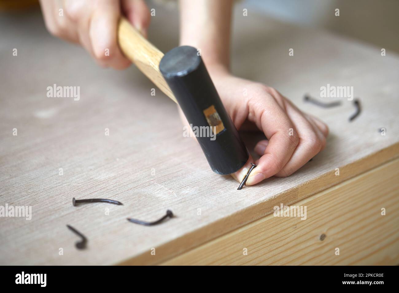 A woman's hand with a hammer hitting her fingers Stock Photo - Alamy