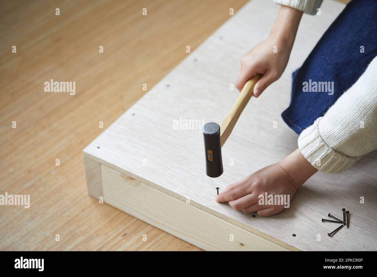 A man hammering a nail into a piece of wood Stock Photo - Alamy