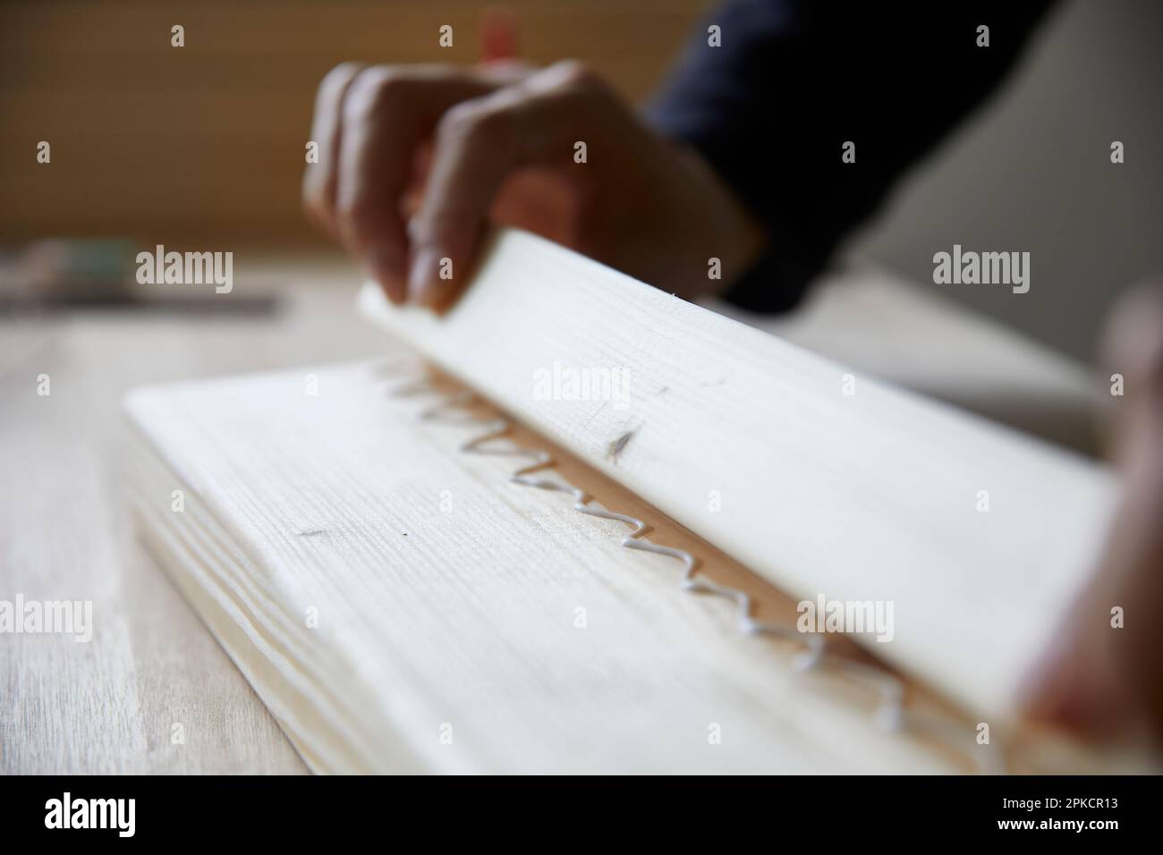 A man doing DIY with bonded square timber Stock Photo - Alamy