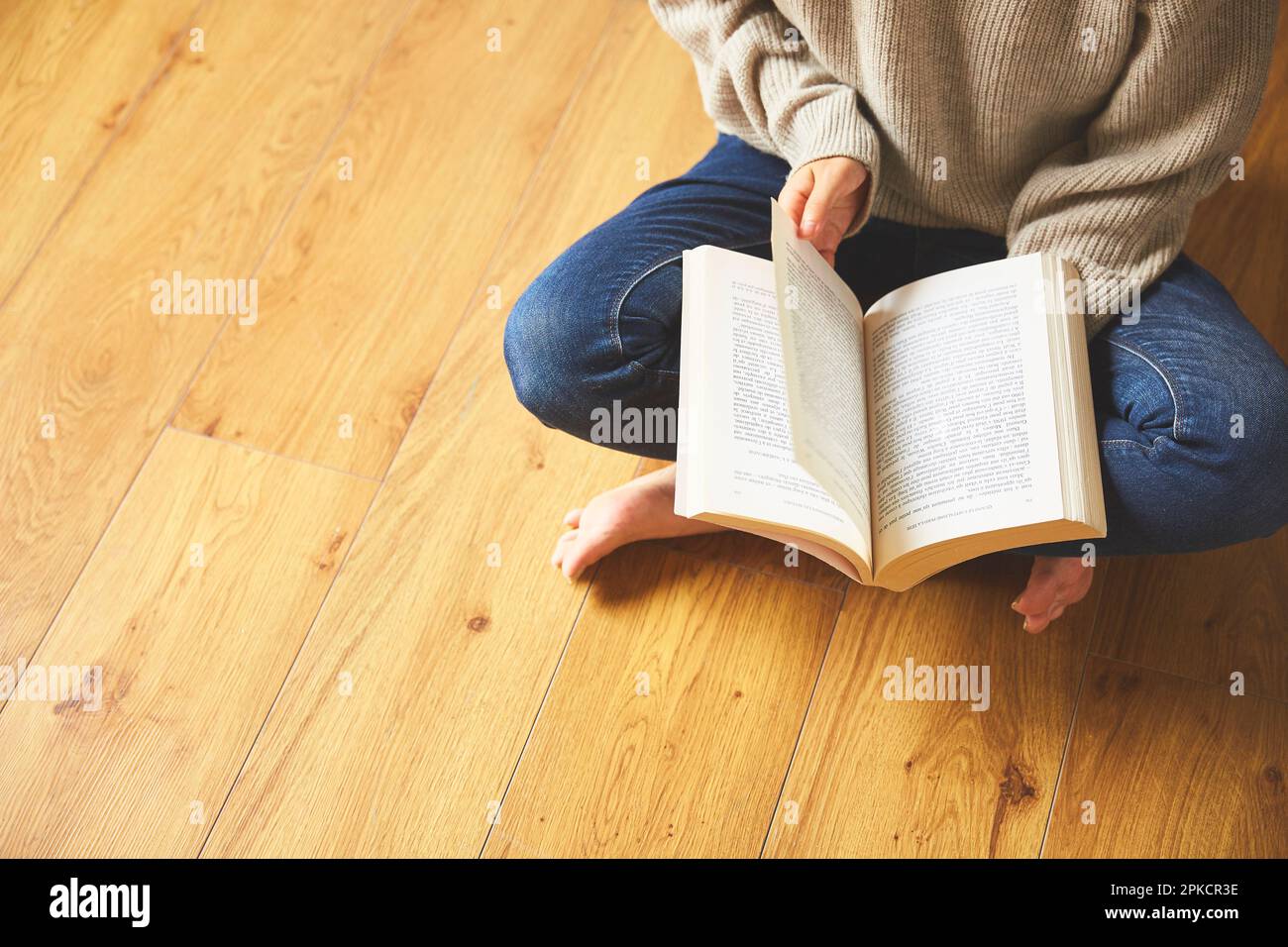Woman sitting on the floor reading a book Stock Photo - Alamy