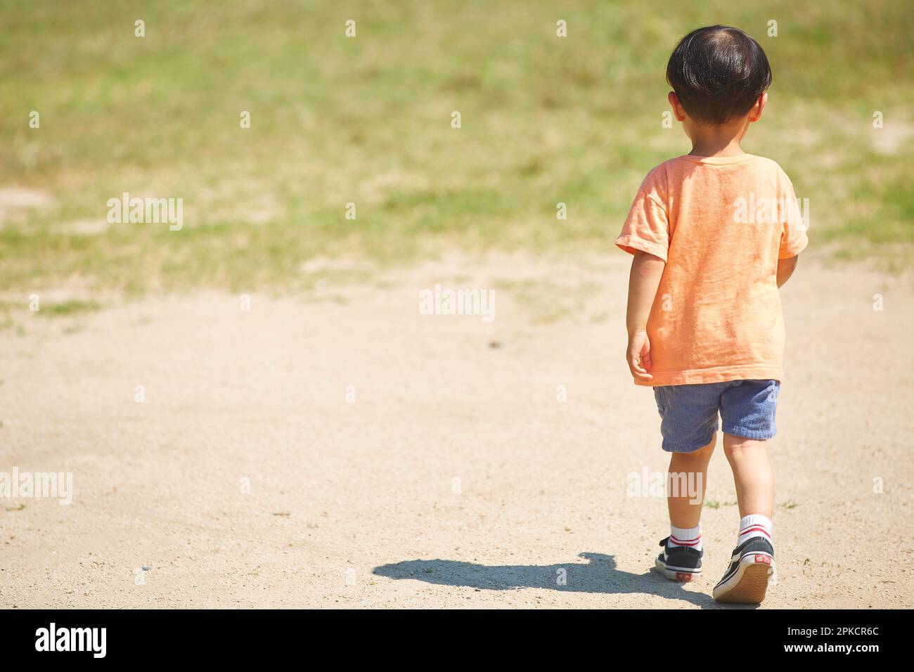 Back view of a boy walking on the ground Stock Photo - Alamy