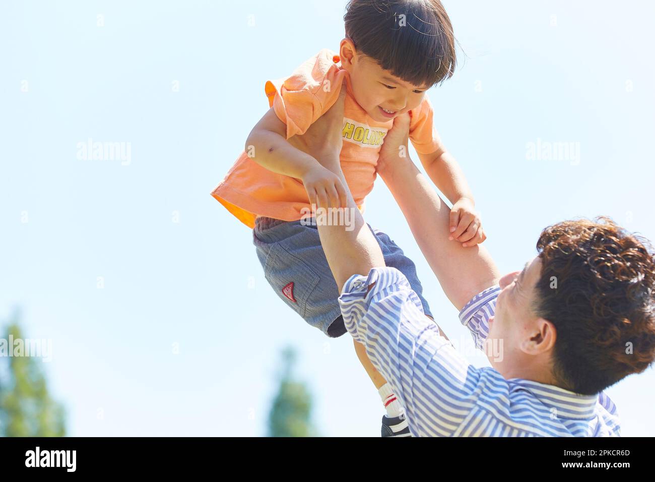 A man lifting a boy high Stock Photo - Alamy