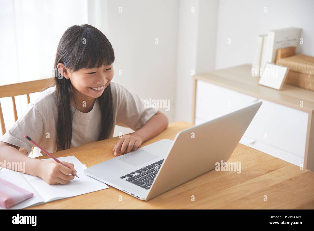Girl learning online in dining room Stock Photo - Alamy