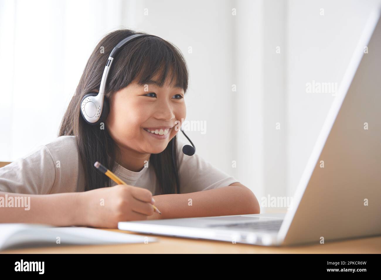 Girl learning online in dining room Stock Photo - Alamy
