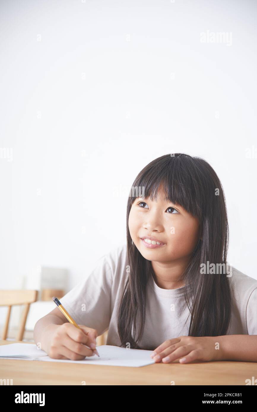 Girl Studying at Dining Table Stock Photo - Alamy