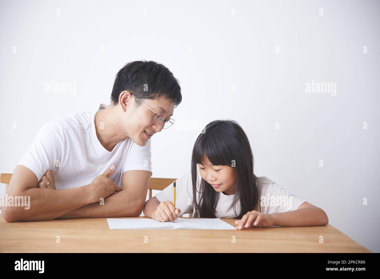 Girl Getting Help With Homework From Father Stock Photo - Alamy