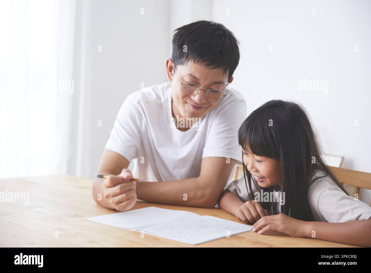A Girl Getting Help With Her Homework From Her Father Stock Photo - Alamy