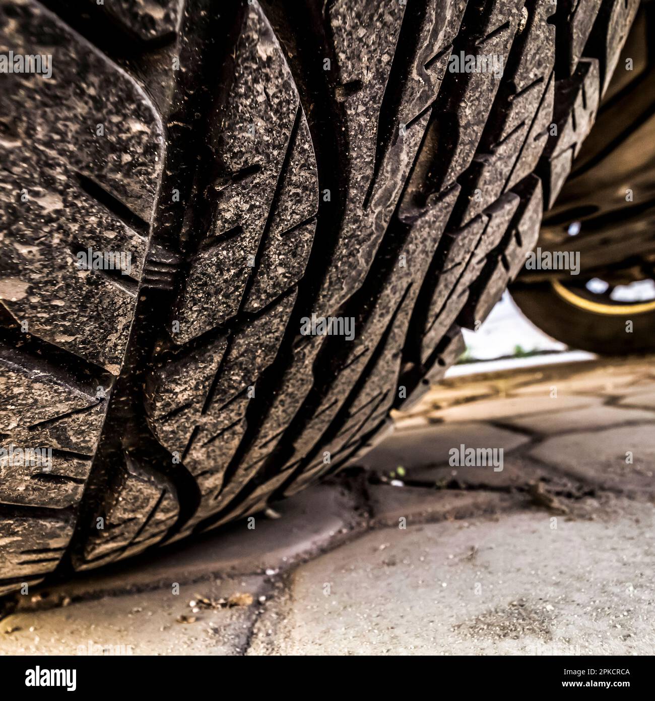 Tread of a wheel of an off-road car standing in the back yard, closeup ...