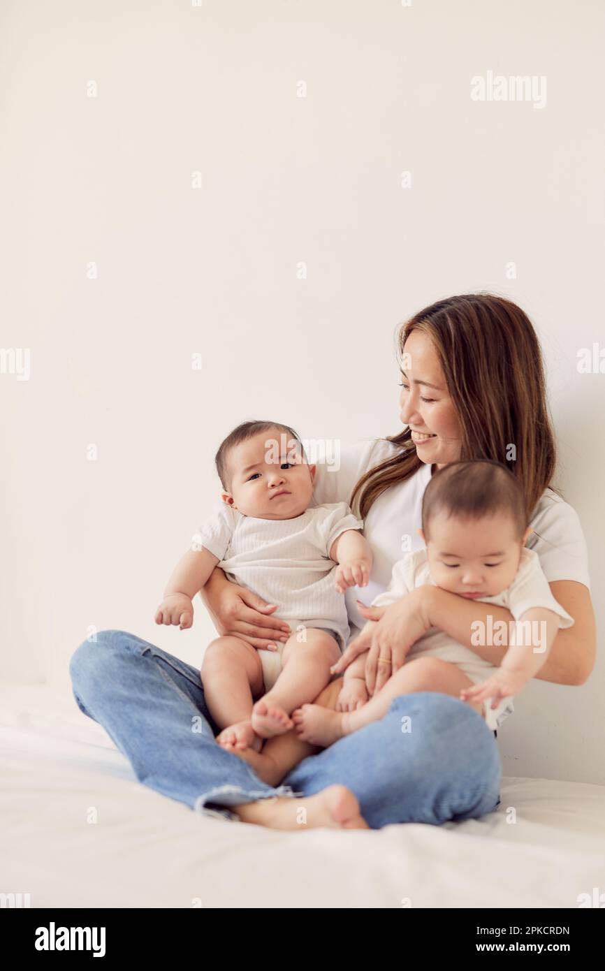 Mother holding baby twins Stock Photo - Alamy