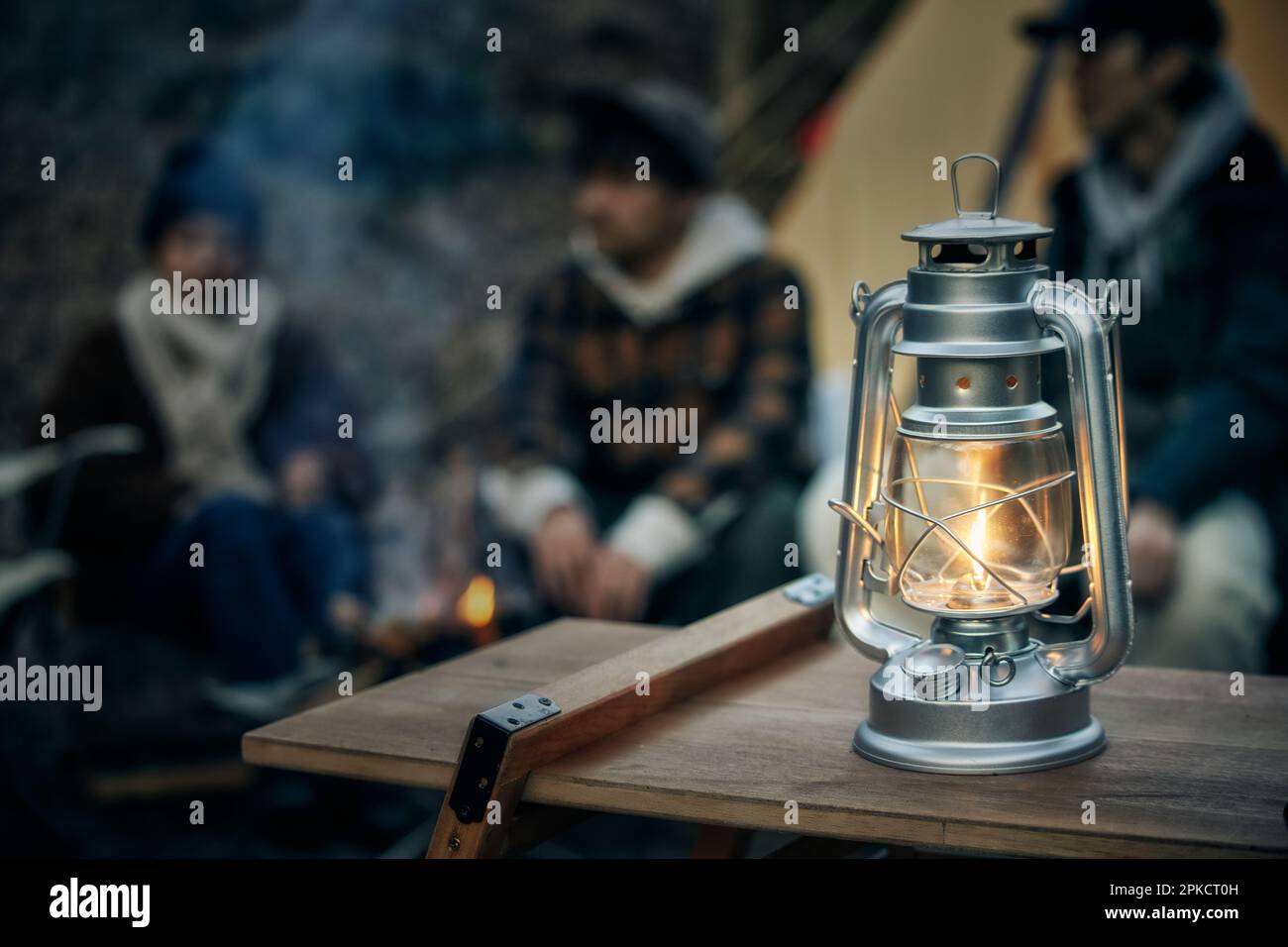Man and woman surrounding campfire with lanterns and back Stock Photo ...