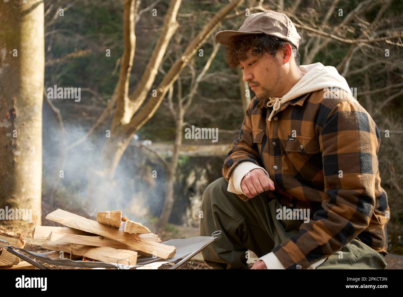 Man building a fire in a winter campsite Stock Photo - Alamy