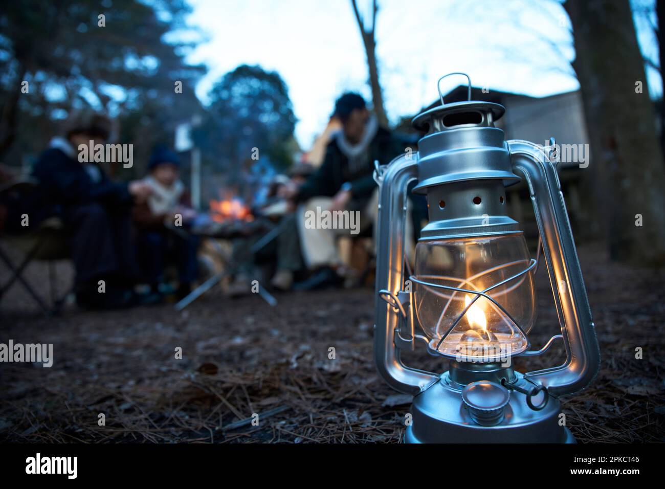 Man and woman surrounding campfire with lanterns and back Stock Photo ...