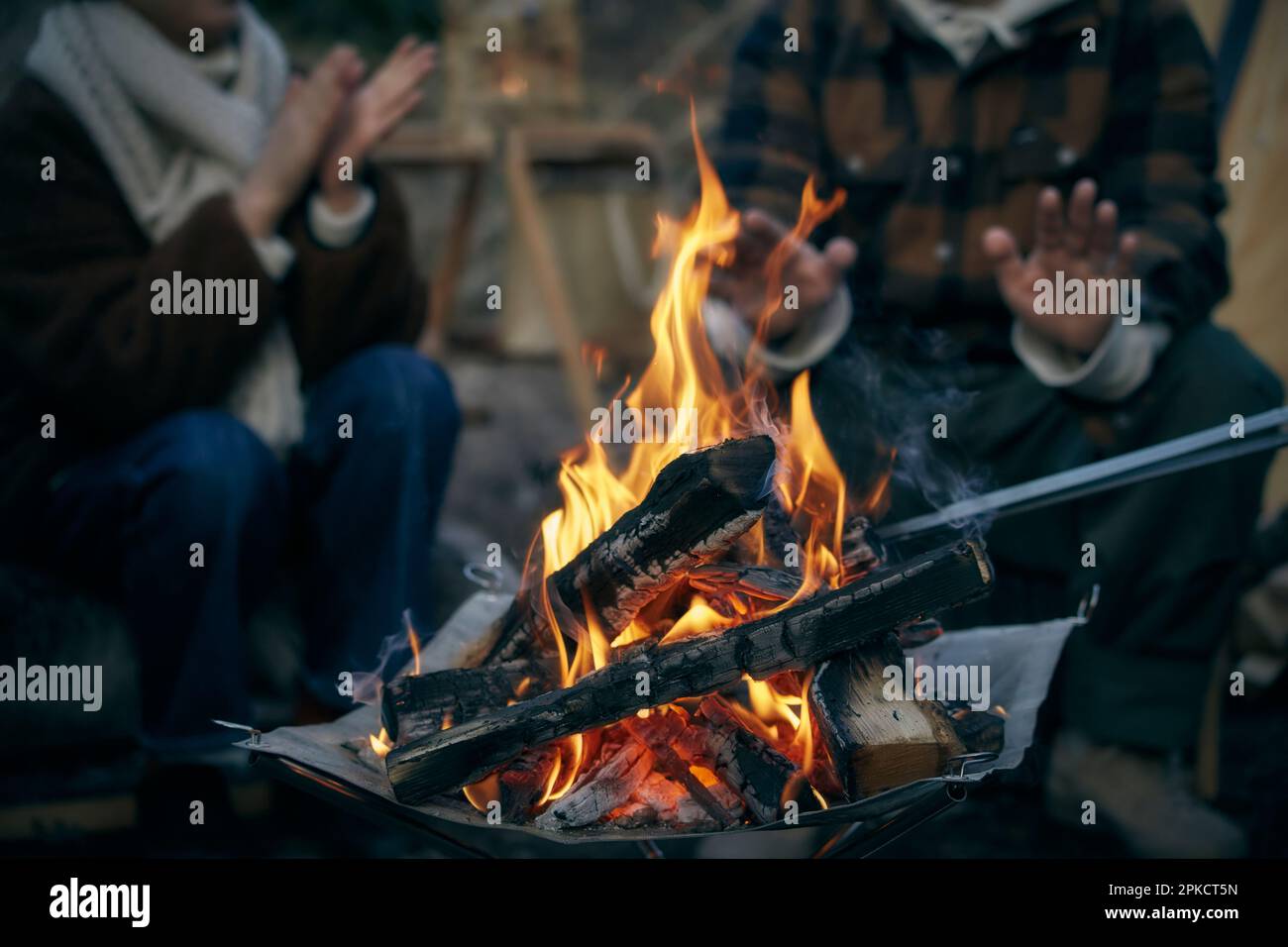 Men and women around a campfire Stock Photo - Alamy