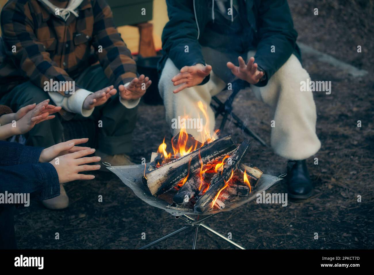 Men and women around a campfire Stock Photo - Alamy