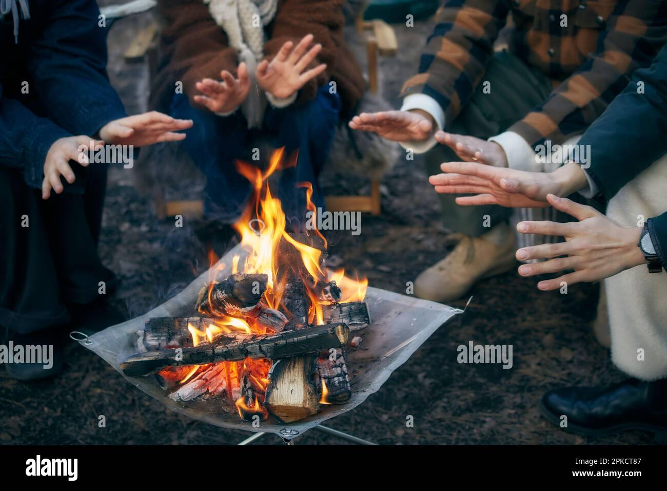 Men and women around a campfire Stock Photo - Alamy