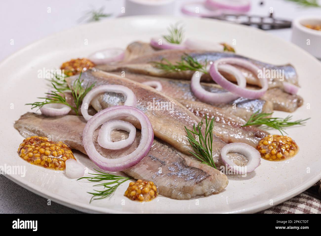 Salted herring with dijon mustard, dill and red onion rings on white ...