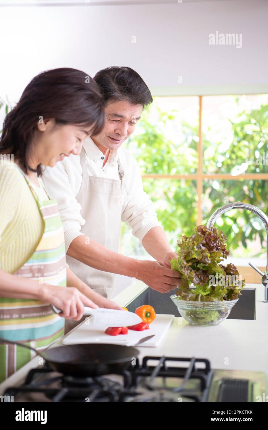 Middle-aged couple cooking in the kitchen Stock Photo - Alamy