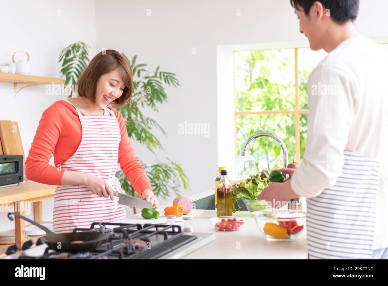 Couple in their 20s cooking in the kitchen Stock Photo - Alamy