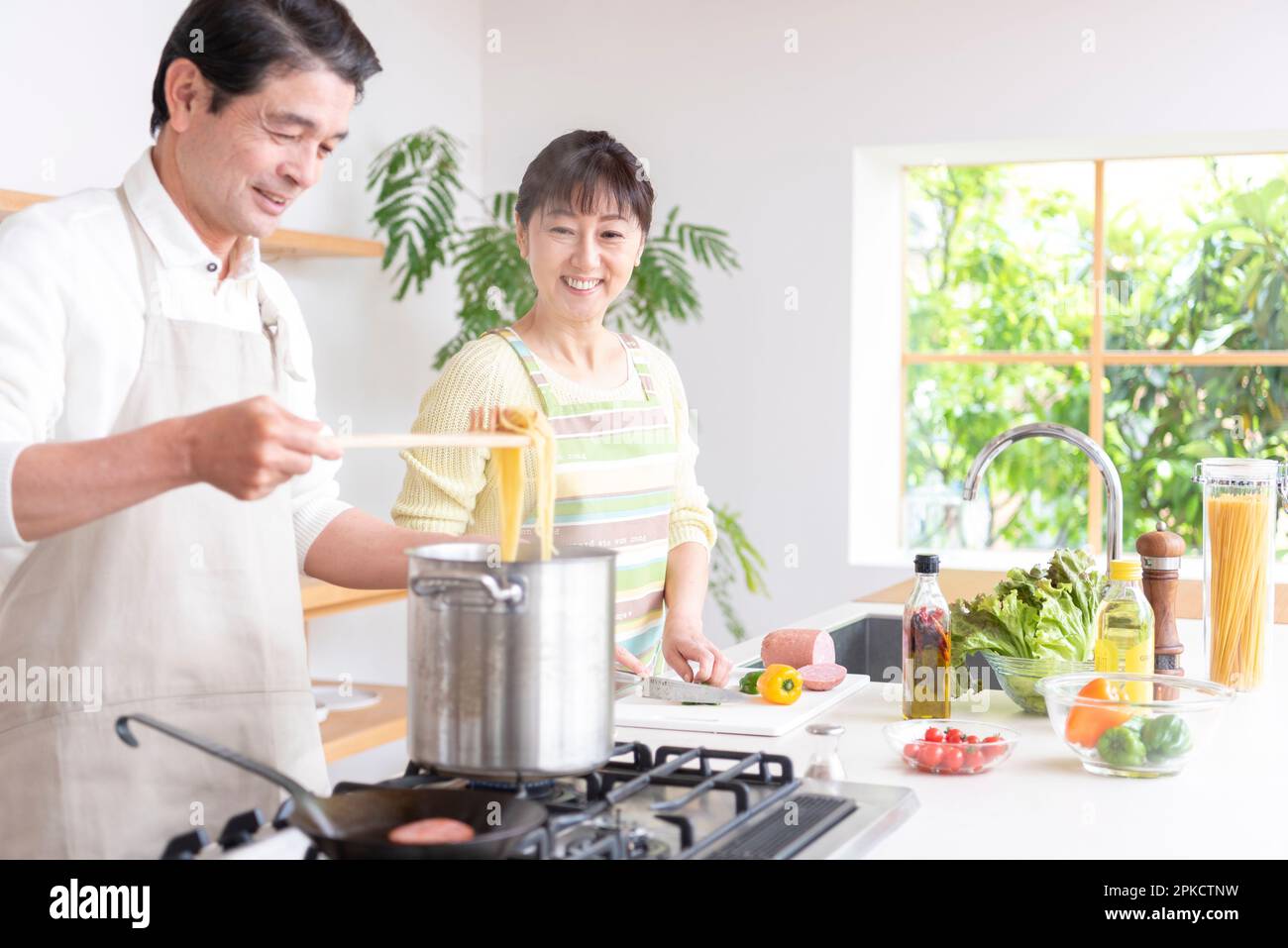 A middle-aged couple cooking in the kitchen Stock Photo - Alamy