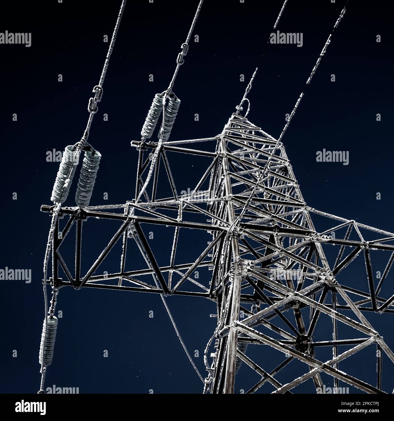 High-voltage wires and poles are covered with frost on a frosty winter ...
