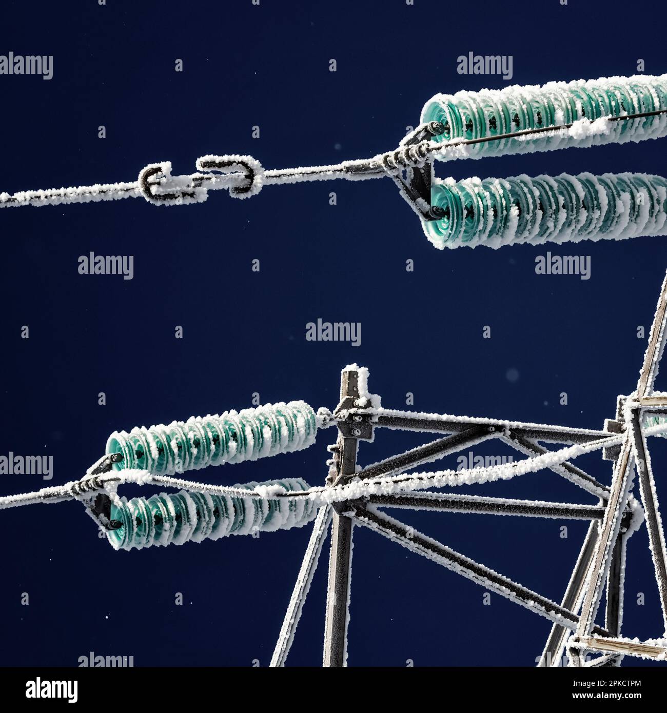 High-voltage wires and poles are covered with frost on a frosty winter ...