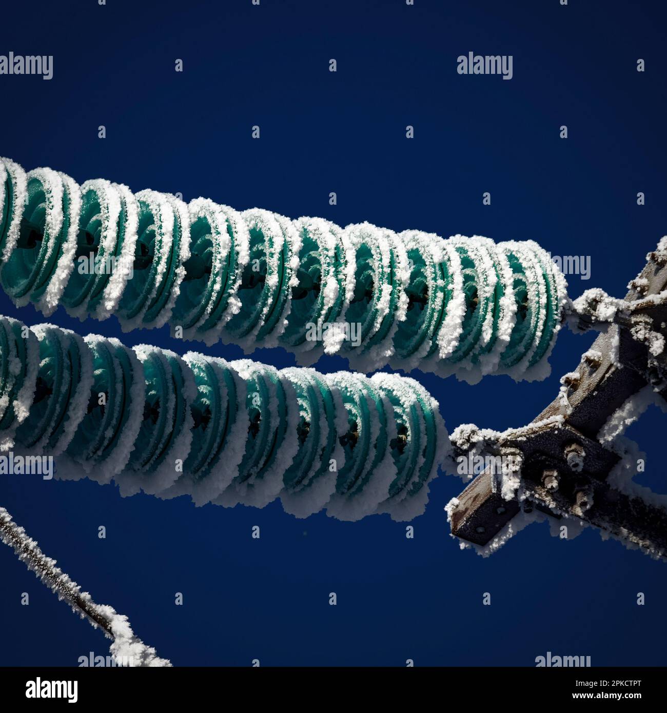 High-voltage wires and poles are covered with frost on a frosty winter ...