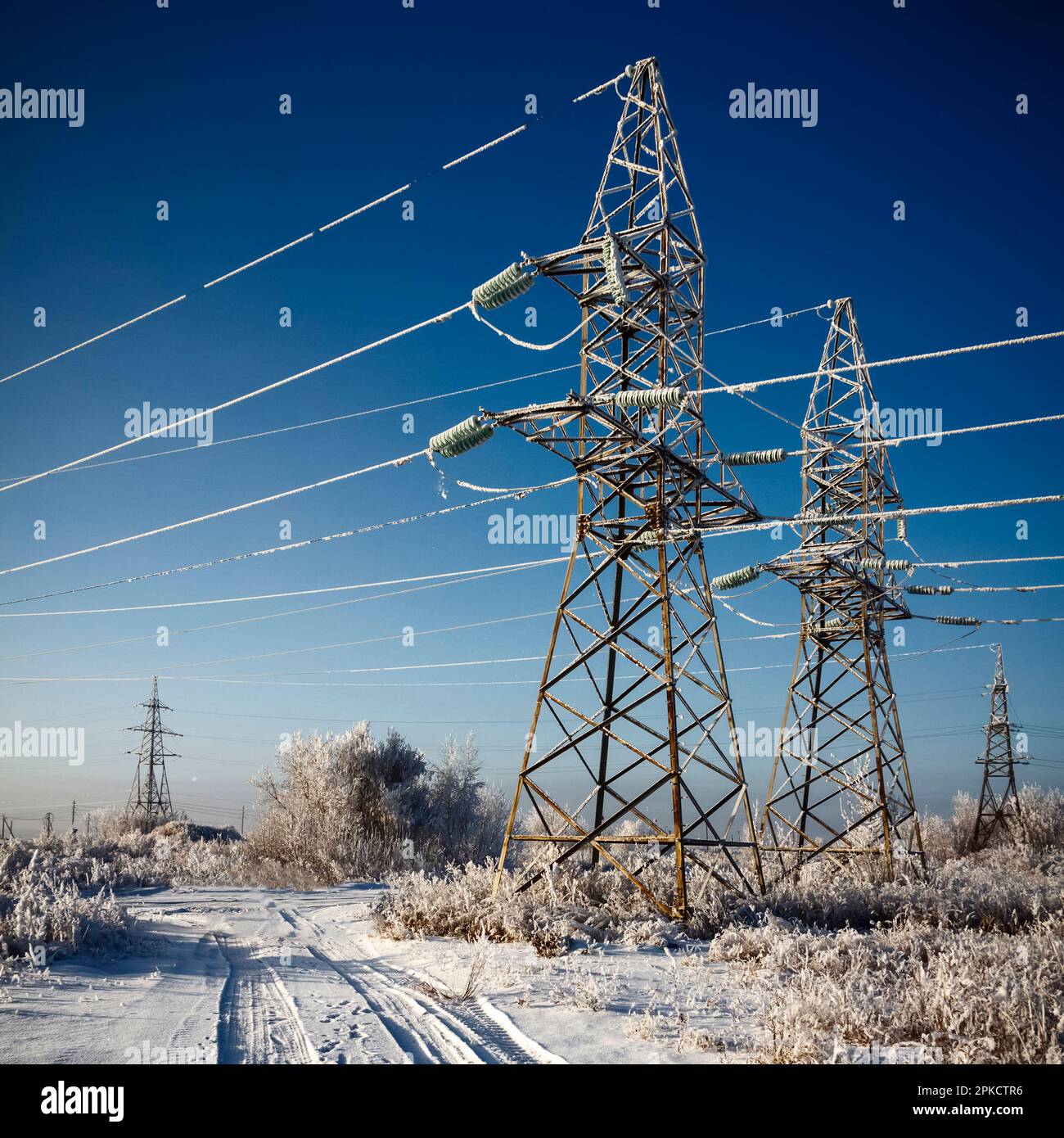High-voltage wires and poles are covered with frost on a frosty winter ...