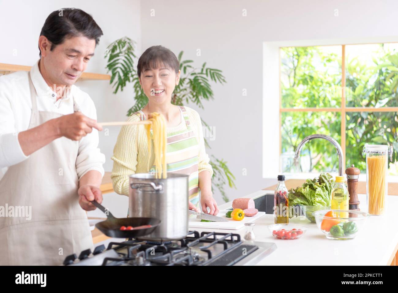 A middle-aged couple cooking in the kitchen Stock Photo - Alamy