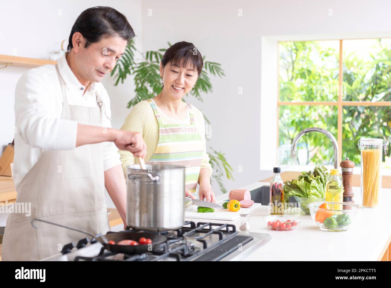 A middle-aged couple cooking in the kitchen Stock Photo - Alamy