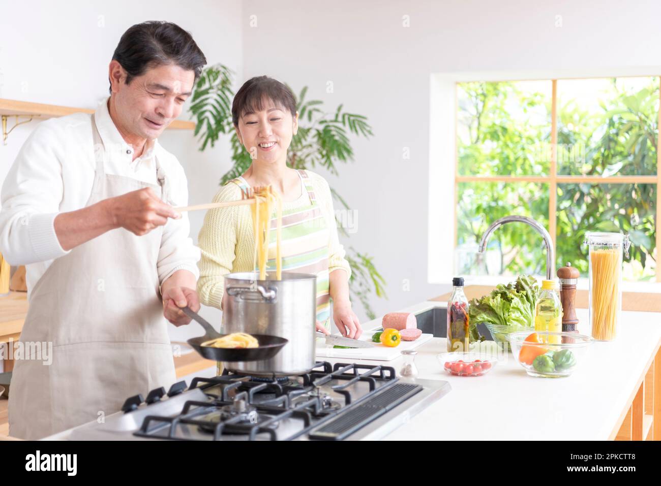 A middle-aged couple cooking in the kitchen Stock Photo - Alamy