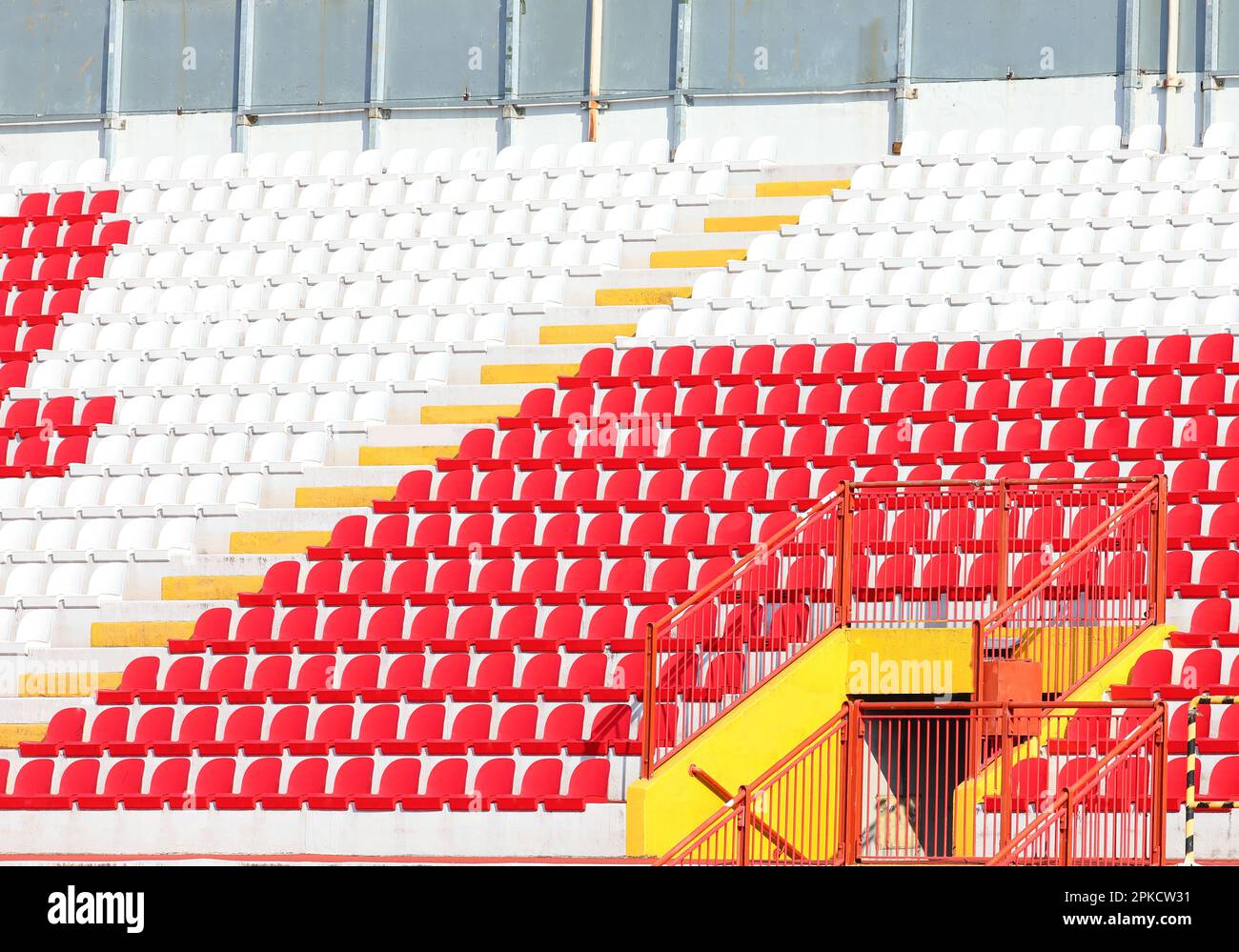 many empty red and white seats in the stadium stands without people and ...